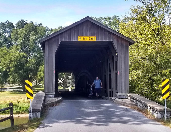 A cyclist pauses to appreciate the bridge's timeless beauty&mdash;a perfect stop along Lancaster County's scenic backroads.