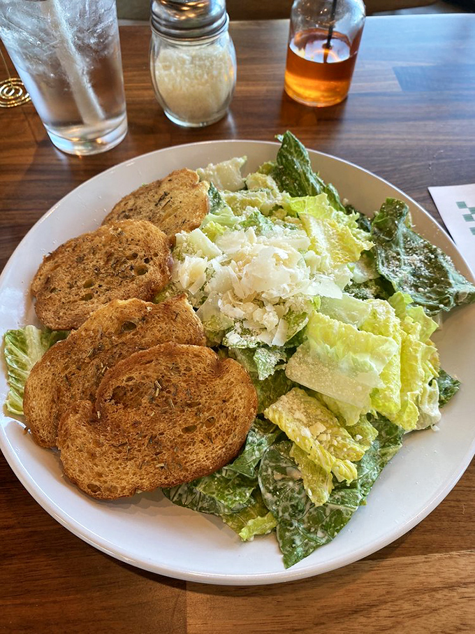 A Caesar salad that respects the classics&mdash;crisp romaine, shaved parmesan, and herbed croutons that weren't born in a bag. Simple done right.