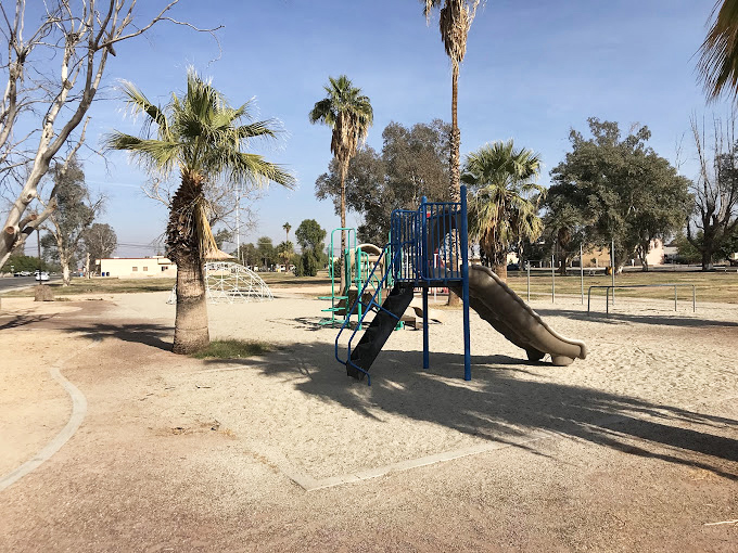 Simple pleasures reign at the local park, where palm trees stand guard over childhood adventures waiting to happen on sun-warmed equipment.