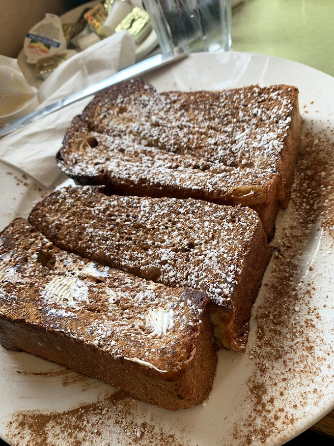 Challah French toast dusted with cinnamon&mdash;thick-cut slices transformed into a breakfast that straddles the line between meal and dessert.