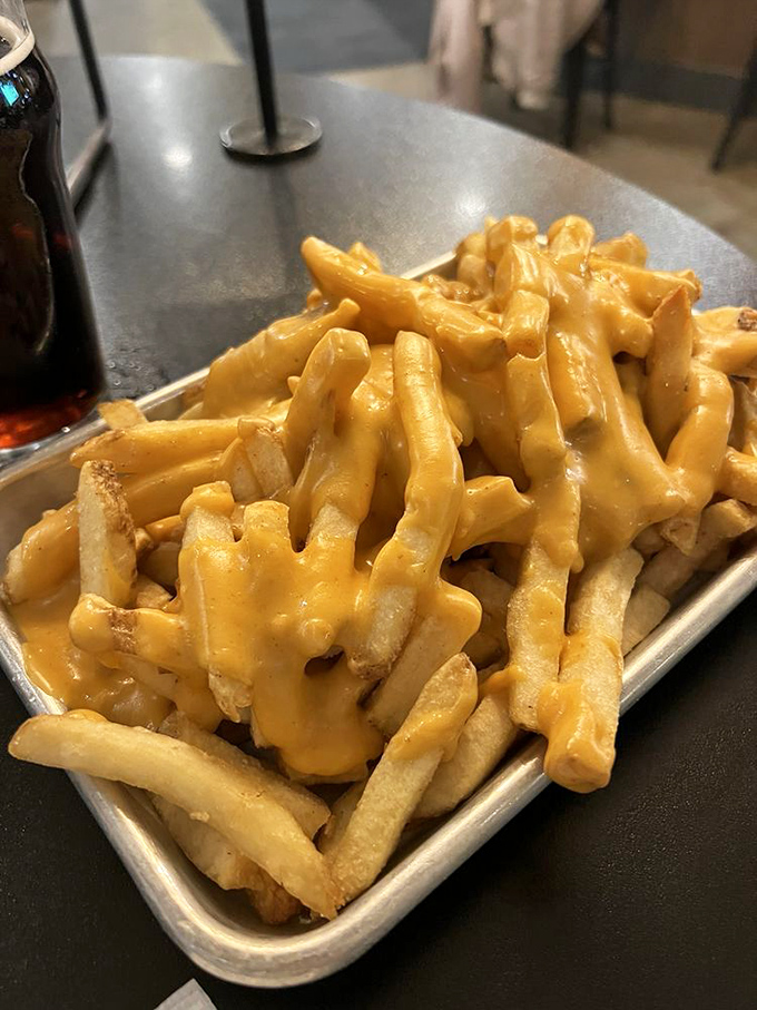 Cheese fries that demand to be shared but inspire selfishness. That golden cheese sauce cascades like delicious lava over perfectly crisp potatoes.