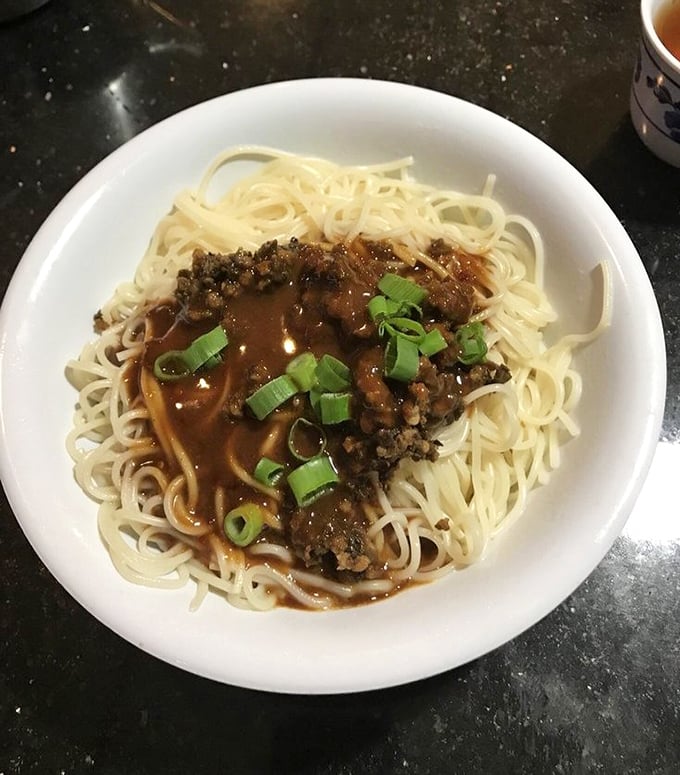 Dan dan noodles that would make a carb-counter weep with joy &ndash; tender strands supporting a savory meat sauce sprinkled with green onions for that perfect finish.