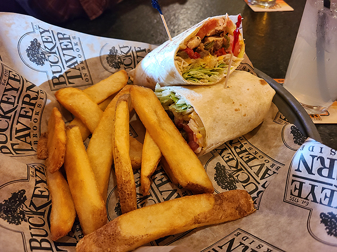 A wrap that's holding more treasures than Indiana Jones ever discovered, with fries standing guard like golden sentinels of satisfaction.