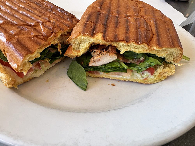 This pressed panini reveals its secrets in layers—toasted bread, fresh greens, and savory fillings that make lunch feel like a celebration.