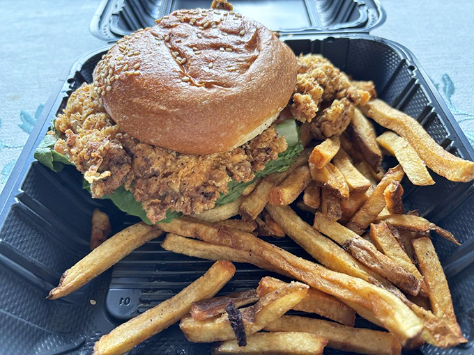 A fried chicken sandwich that demands two hands and your full attention, with fries that could start their own fan club.