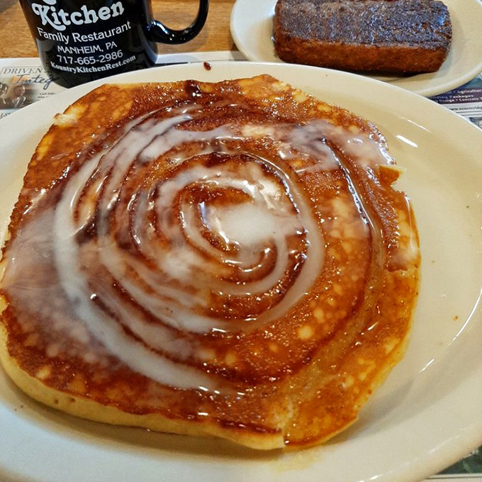 This cinnamon swirl pancake isn't just breakfast—it's dessert with permission to eat it before noon. That spiral of icing is basically a road map to happiness.