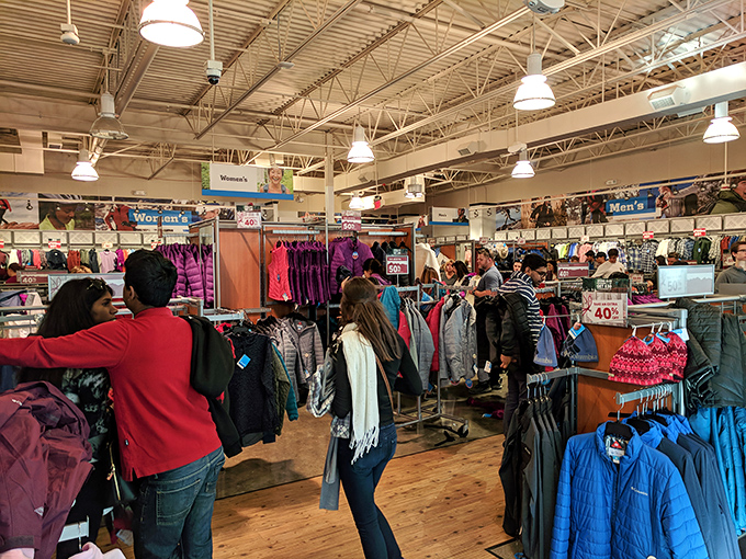 The thrill of the hunt in action&mdash;shoppers navigate racks of discounted outerwear like seasoned explorers tracking elusive bargains in their natural habitat.