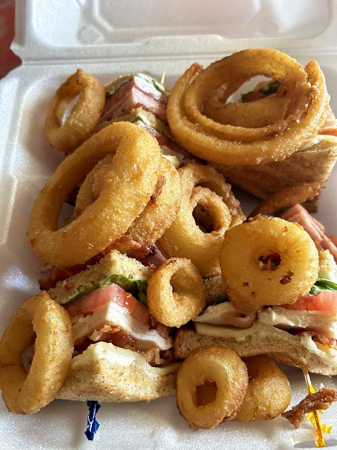This club sandwich with onion rings isn't just lunch&mdash;it's architectural achievement with layers of satisfaction in every bite.