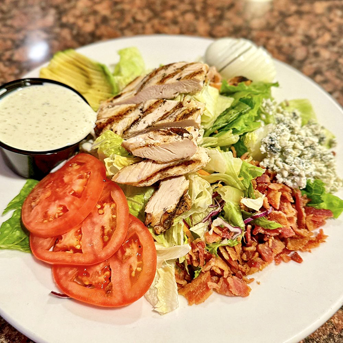 This Cobb salad isn't just checking boxes &ndash; it's redefining them. Grilled chicken, bacon, blue cheese, and fresh vegetables arranged with artistic precision.