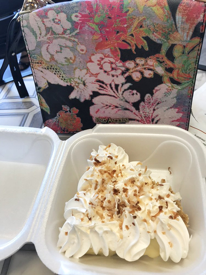 The coconut cream pie wears its toasted coconut flakes like confetti, celebrating the marriage of tropical flavor and cloud-like whipped cream.