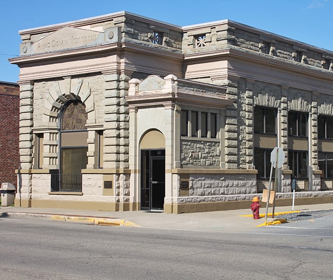 The old bank building's stonework tells stories of a time when financial institutions were built to inspire confidence through sheer architectural gravitas.