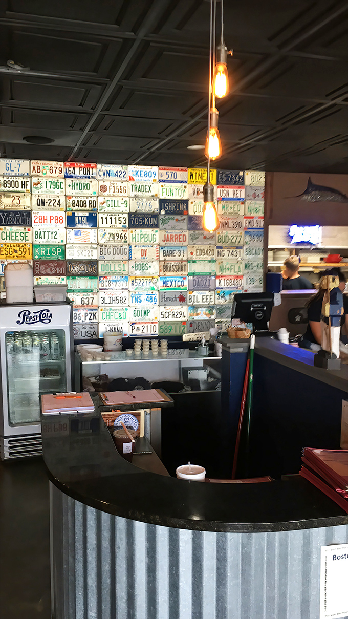 Where seafood magic happens. The license plate collection continues behind the counter, each one representing someone who made the pilgrimage for perfect bisque.