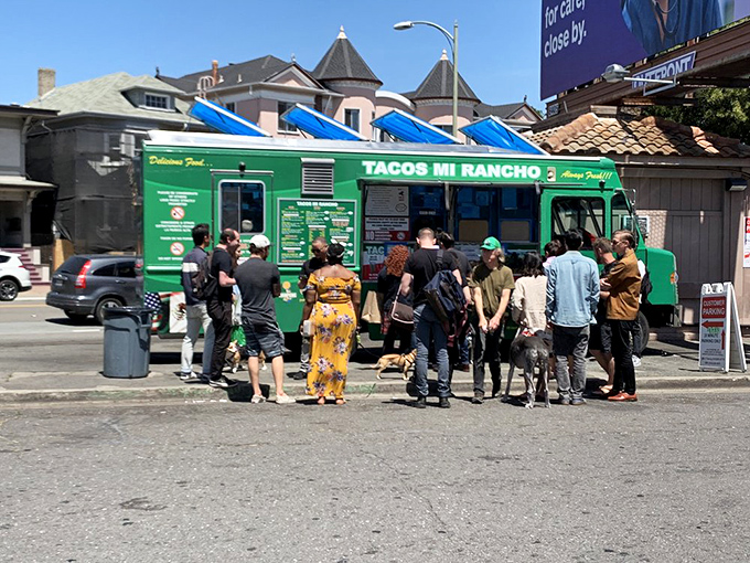 A diverse crowd gathers around this green beacon, proving great food transcends all boundaries and backgrounds. 