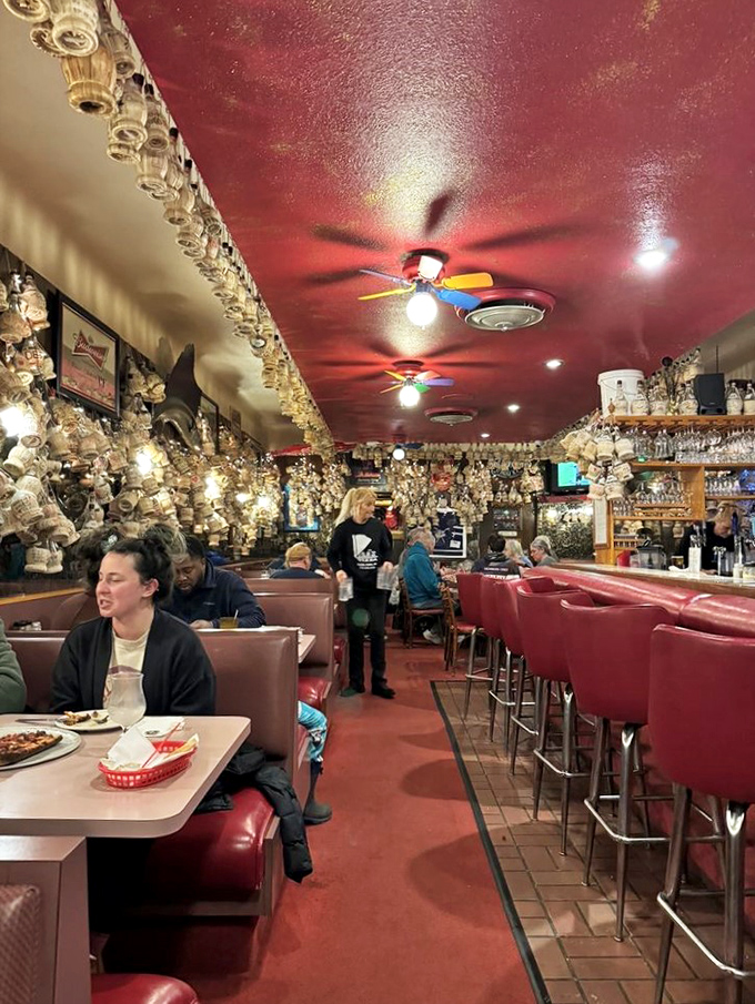 Red vinyl booths have witnessed decades of first dates, family celebrations, and the universal expression of pizza bliss.