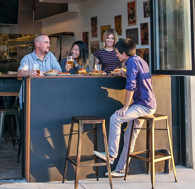 The universal language of good food brings friends together at Humble Potato's counter seating, where every bite sparks joy and conversation.