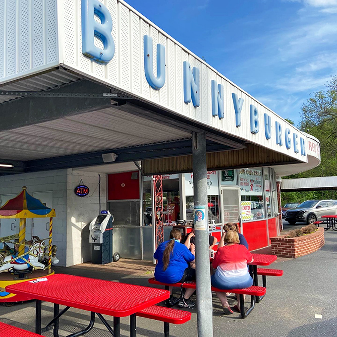 Under the BUNNYBURGER sign, picnic tables become conference rooms for the most important business of all: enjoying a perfect meal. 
