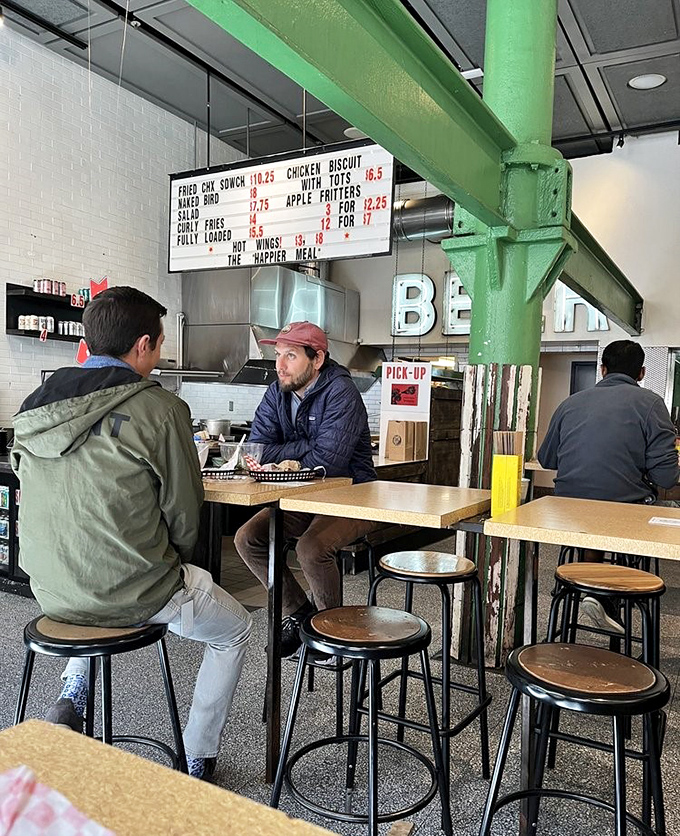 The green support beam adds industrial charm while diners engage in the sacred ritual of the lunch meeting&mdash;business talk punctuated by bites of exceptional chicken.