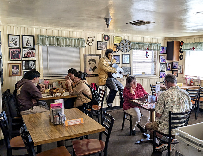 Diners enjoy their meals beneath the watchful gaze of a life-sized Elvis statue&mdash;because what's a 50s experience without The King holding court?
