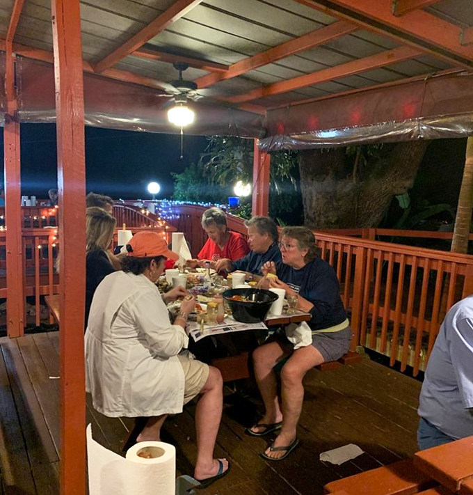 Nighttime seafood feasts under string lights create memories that last longer than sunburns. These folks know what vacation perfection tastes like.