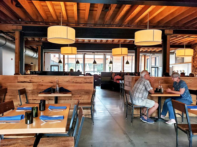 The dining room hums with conversation and clinking glasses. Wooden booths create intimate spaces for everything from first dates to family gatherings.