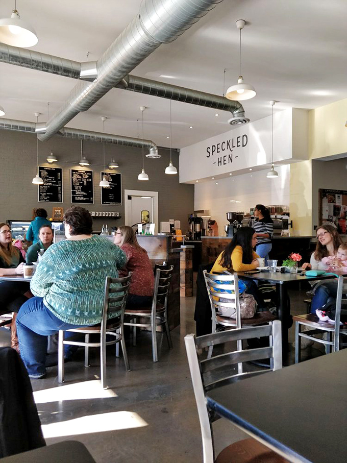 A bustling dining room where strangers become temporary neighbors. The exposed ductwork and pendant lighting create the perfect backdrop for morning conversations and coffee revelations.