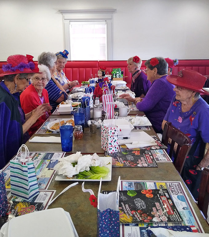 The Red Hat Society ladies know where the good food is—their colorful hats almost as vibrant as the conversations around the table.
