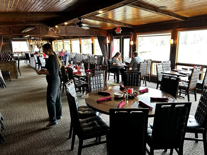 The dining room balances rustic charm with picture windows framing Tainter Lake – supper club serenity at its finest.