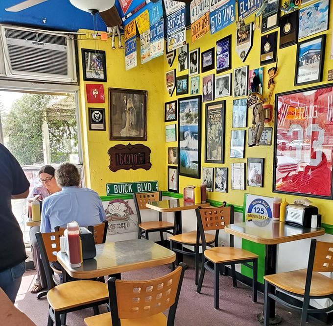 Yellow walls covered in memories create the perfect backdrop for diners enjoying their momentary escape into hot dog bliss.