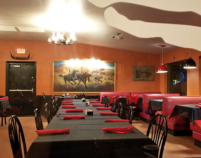 Red napkins stand at attention on black tablecloths while western artwork watches over diners like guardians of the beef experience.