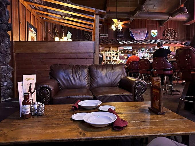 The dining area balances rustic charm with comfortable seating, where leather couches invite you to lounge while digesting what might be the best steak decision of your life.
