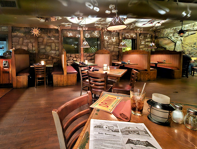 Cozy booths nestled against cave-like walls create dining nooks that feel both intimate and adventurous. Indiana Jones would approve of this decor.