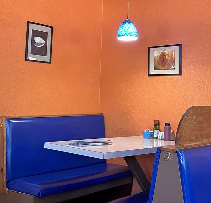 Orange walls and blue booths create a sunrise vibe that perfectly complements your morning meal. Breakfast with a side of cheer.