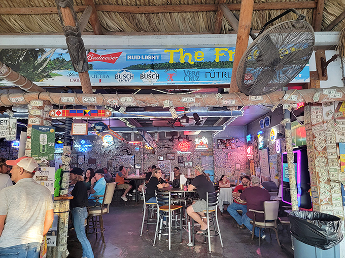 The thatched ceiling and neon-lit interior create a "beach shack meets dive bar" vibe that somehow feels exactly right. 