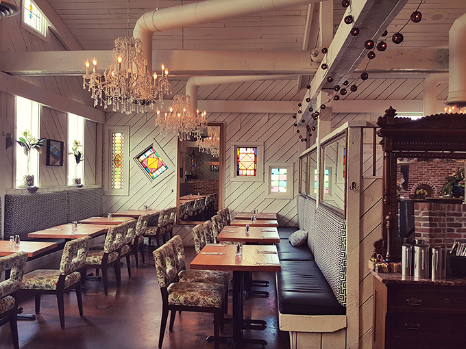 Chandeliers and diagonal wood paneling create a dining room that feels both upscale and welcoming. Southern hospitality meets Northern sophistication.