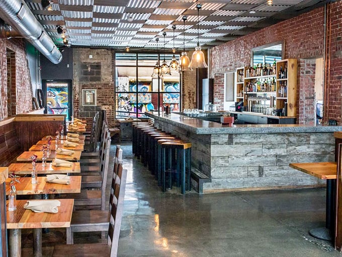 The bar area whispers, "Stay awhile." Exposed brick, pendant lighting, and those wooden tables practically guarantee good conversations and better meals