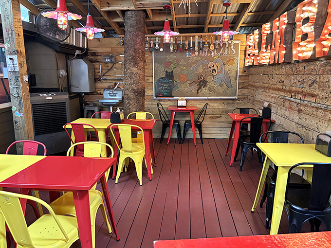 Vibrant red and yellow metal chairs pop against rustic wooden walls. Even the furniture here has personality to spare.