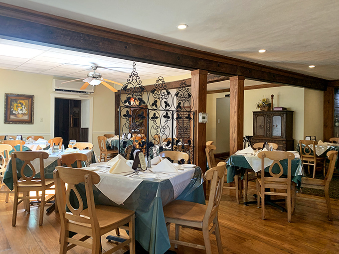 Wrought iron dividers and wooden beams create intimate dining spaces where every table feels like the best seat in the house.