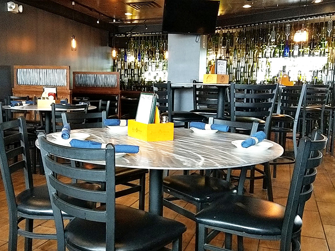 Modern meets cozy in the dining area, where marble-topped tables and blue napkins await the next round of happy diners.