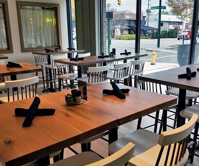 Tables set with military precision but Southern hospitality, where every rolled napkin promises a clean slate for culinary adventures.