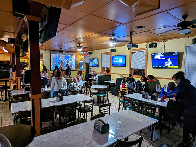 The dining area buzzes with conversation and anticipation. Those TVs aren't the main attraction – they're just something to look at between bites of barbecue glory.