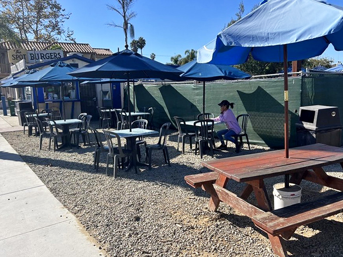 Blue umbrellas provide shade for life's most important decisions: one burger or two, chocolate shake or vanilla, and whether to save room for dessert.