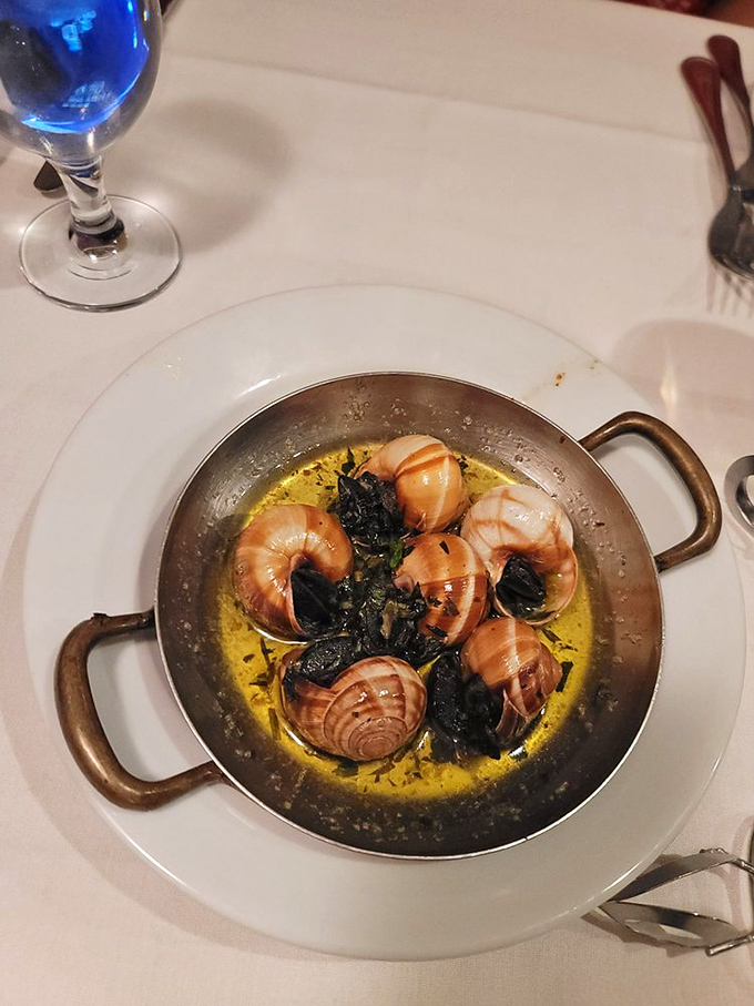 Escargot swimming in garlic butter&mdash;proof that sometimes the most intimidating menu items deliver the most memorable flavor bombs.