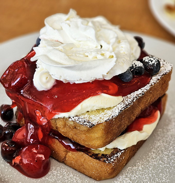 French toast that crosses into dessert territory, with berry compote cascading down like a sweet lava flow. Breakfast or dessert? Yes, please.