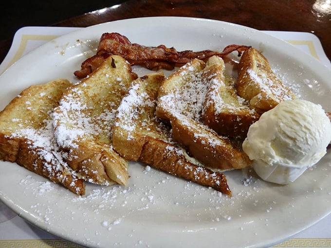 French toast that's had a proper powdered sugar snowfall, with bacon standing guard to ensure the perfect sweet-savory balance. Breakfast diplomacy at its finest.