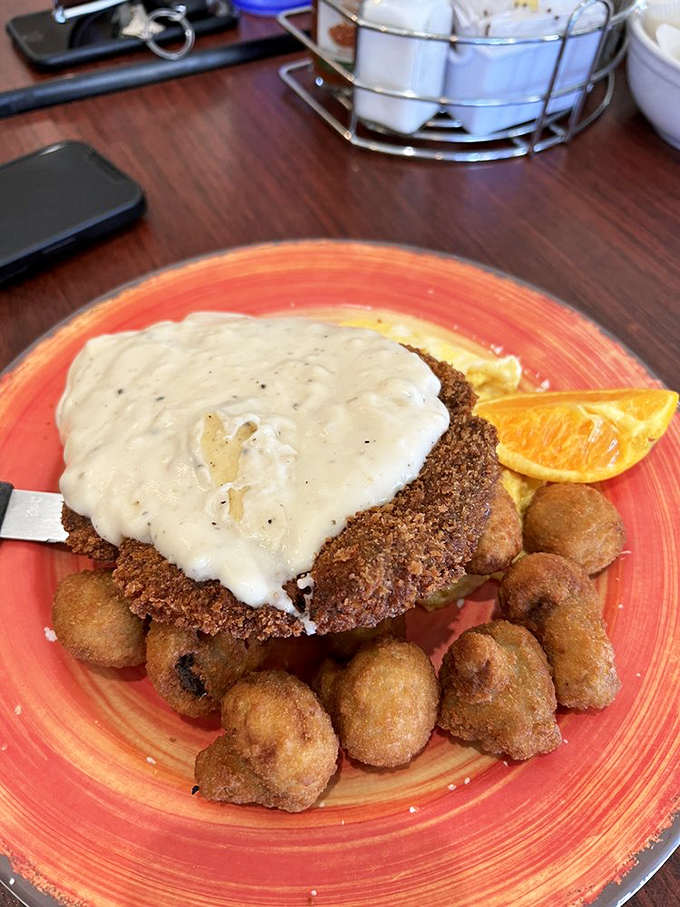 Country fried steak smothered in gravy with a side of golden potato nuggets. This plate has "nap afterward" written all over it.