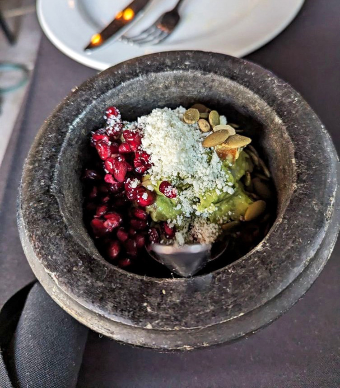 A stone molcajete cradles the holy trinity of Mexican flavors&mdash;pomegranate jewels, creamy avocado, and pepitas&mdash;ready for your chip-dipping pleasure.