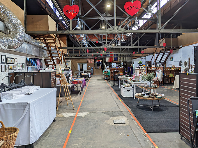Down the industrial-chic corridor, red hearts dangle overhead like breadcrumbs leading you deeper into this treasure-hunting wonderland.