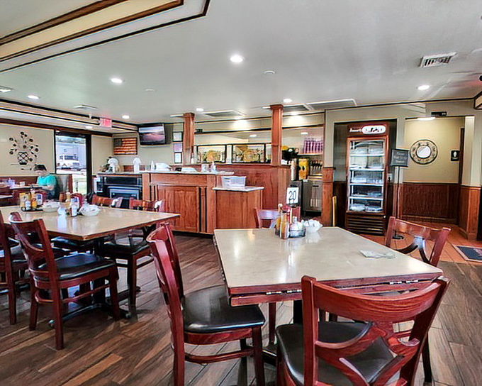 The dining room hums with anticipation as servers navigate between tables. That wooden counter has heard more town secrets than the local barber.