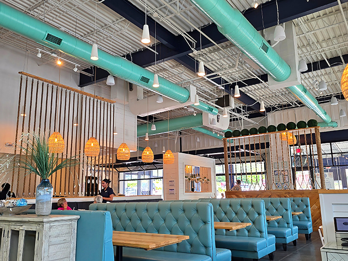 Turquoise accents and rope dividers create distinct dining zones without walls—like an open-concept beach house where everyone gets the good seat.