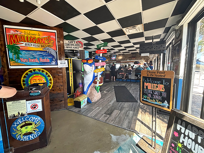Coastal kitsch meets genuine charm at the entrance – where a life-sized shark and colorful signage set the tone for the seafood adventure ahead.